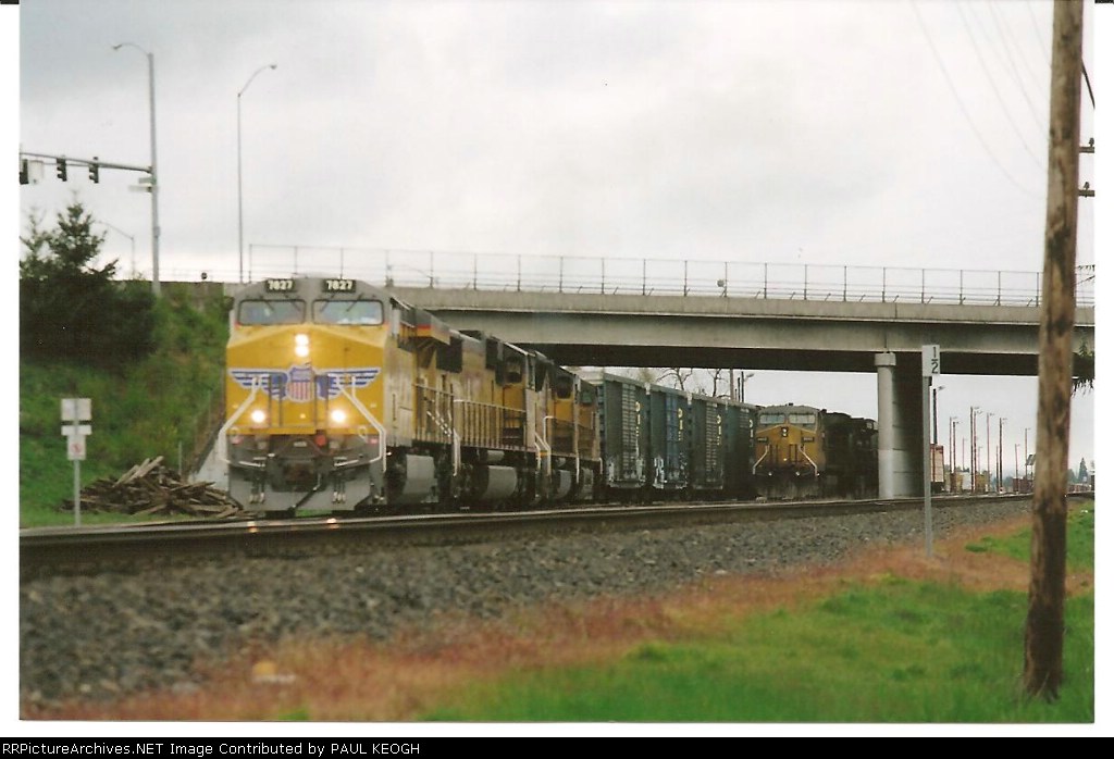 UP 7827 goes under the 10th St. bridge as she rolls south with a manifest train.